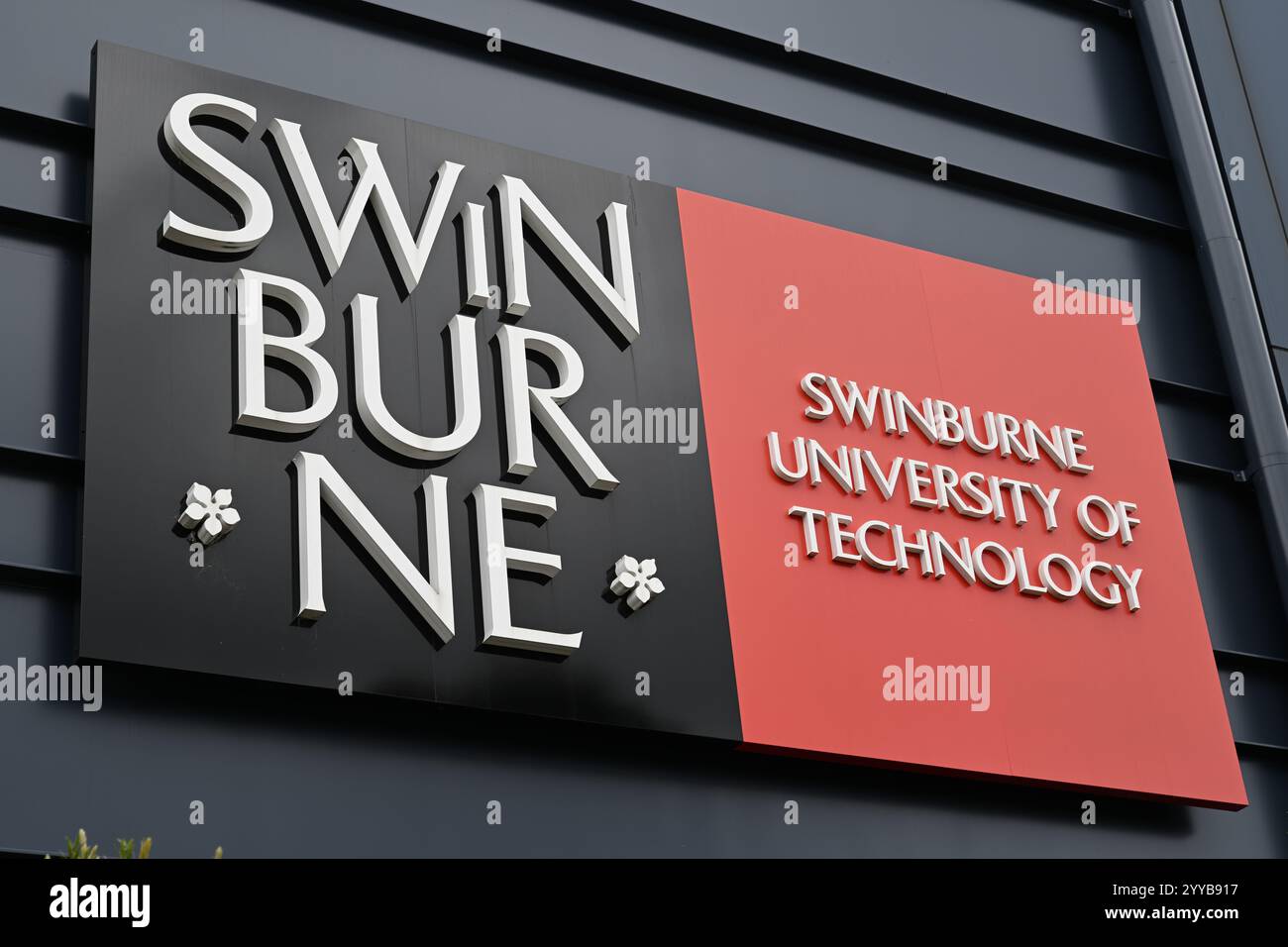 Swinburne University of Technology logo on the dark wall of a building ...