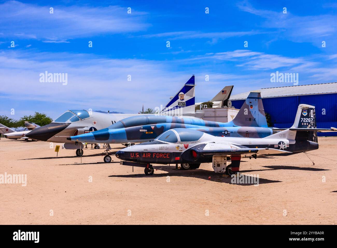 A US Air Force jet is parked next to another jet. The two jets are blue ...