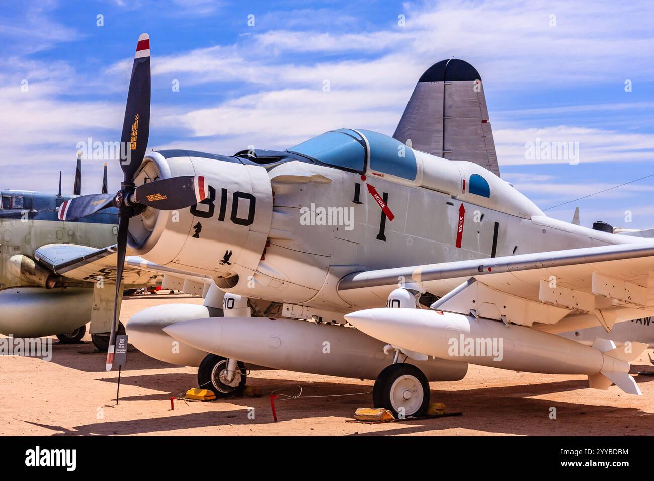 A small plane with the number 910 on the side sits on the ground. The ...