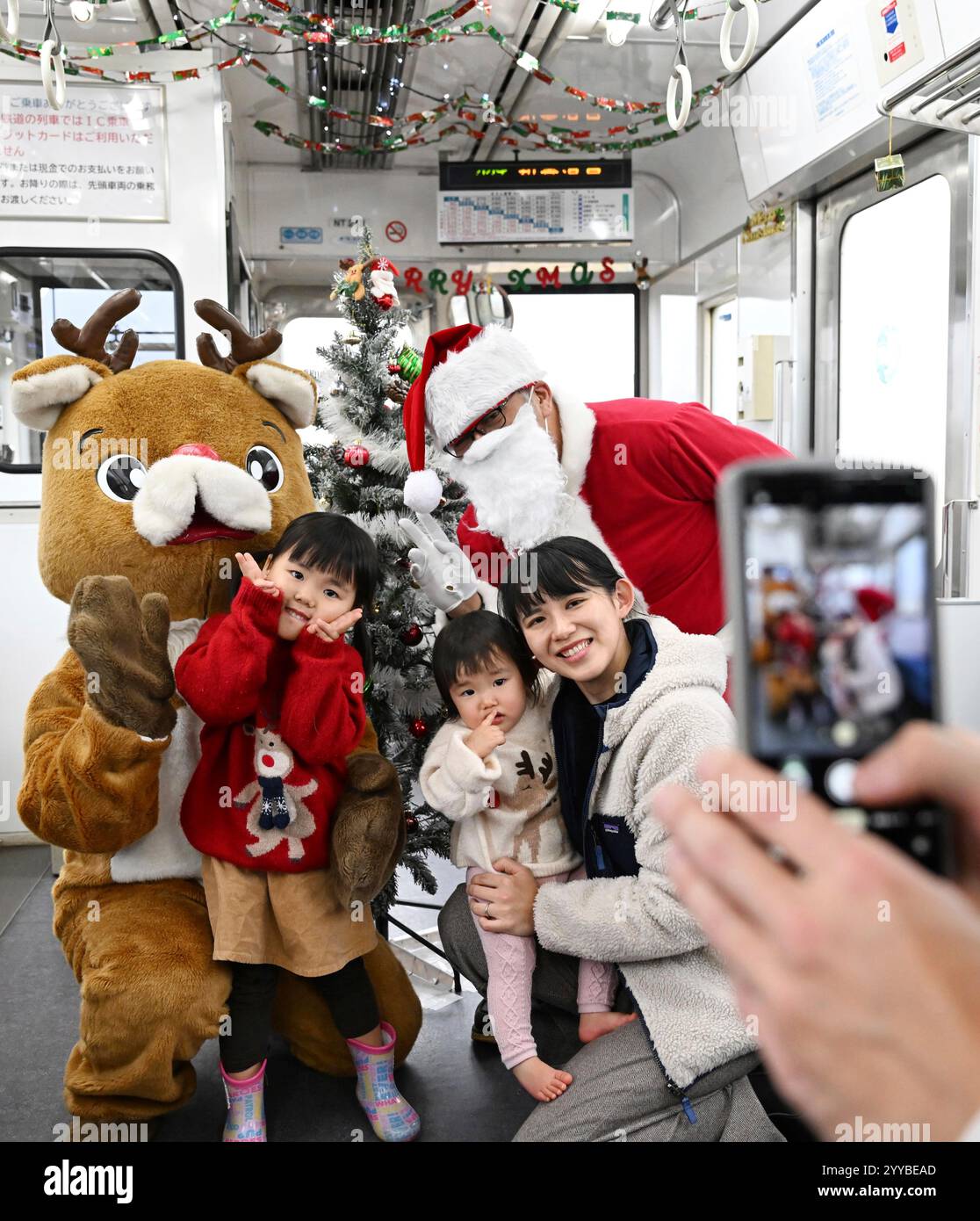 Passengers pose for photo with Santa Claus and his reindeer. "Santa ...