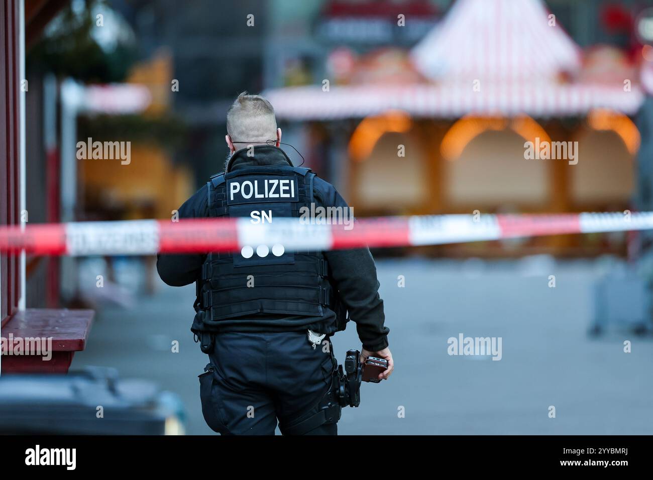 Magdeburg, Germany. 21st Dec, 2024. A police officer stands behind a ...