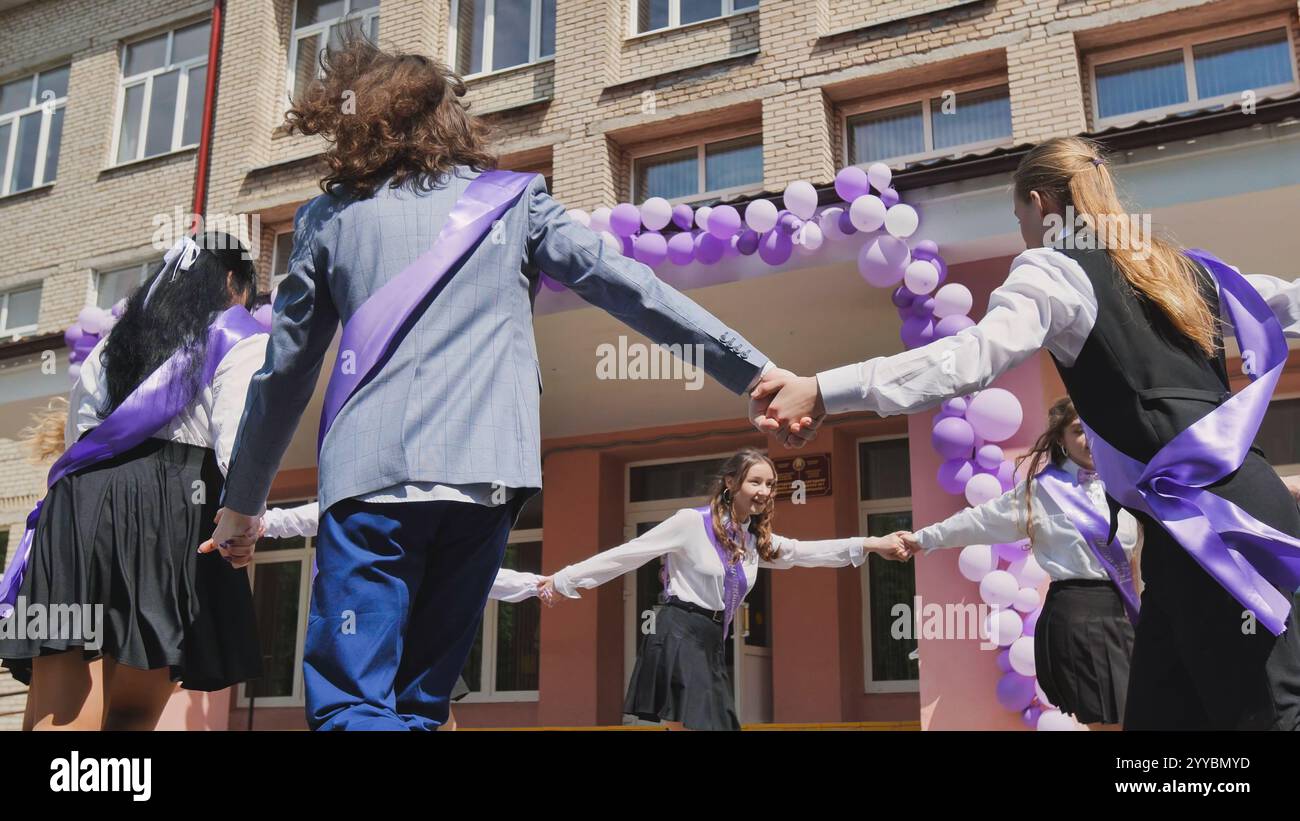 Group of happy students wearing purple ribbons, holding hands and ...