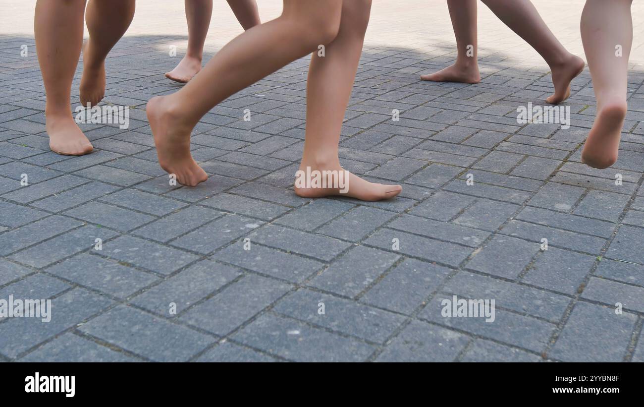 Joyful students celebrate the end of school, walking barefoot on warm ...