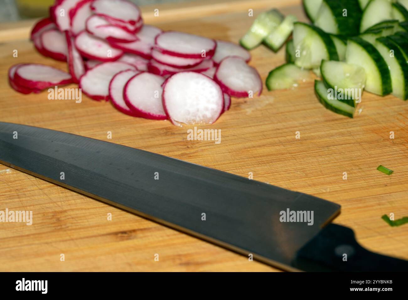 Chopped Up SlicedCuecumber and Radish on a Chopping Board in a Kitchen ...