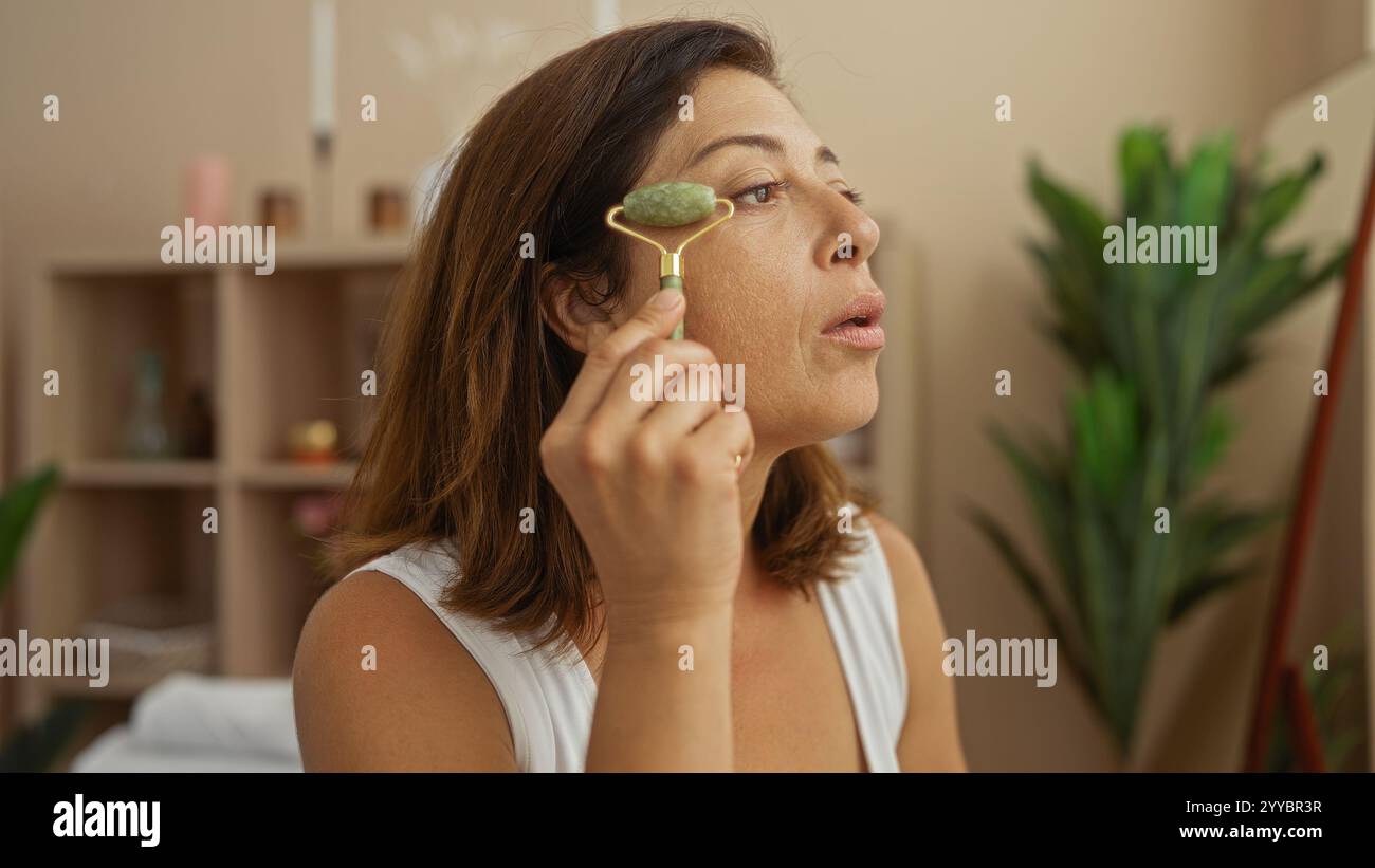 Woman using facial roller at spa, showcasing wellness routine in a ...