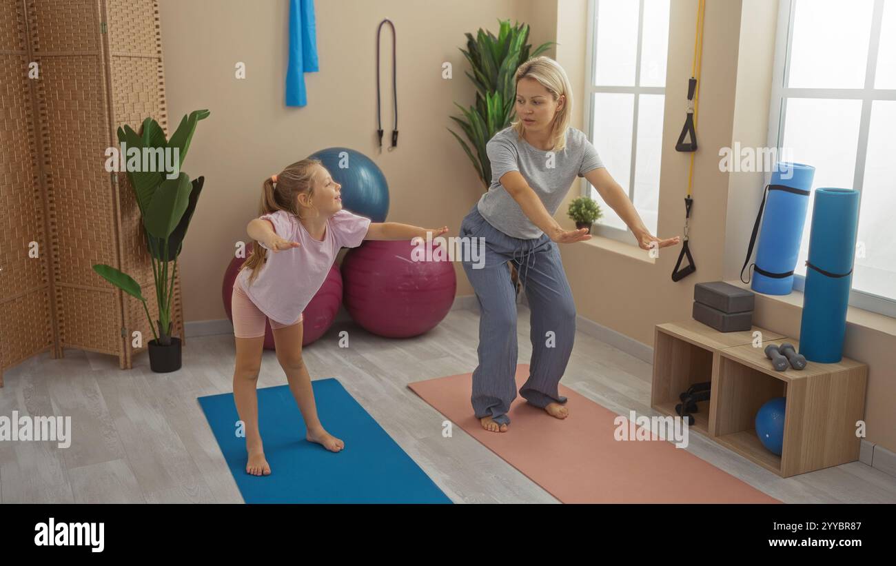 Mother and daughter practicing exercises together in an indoor ...
