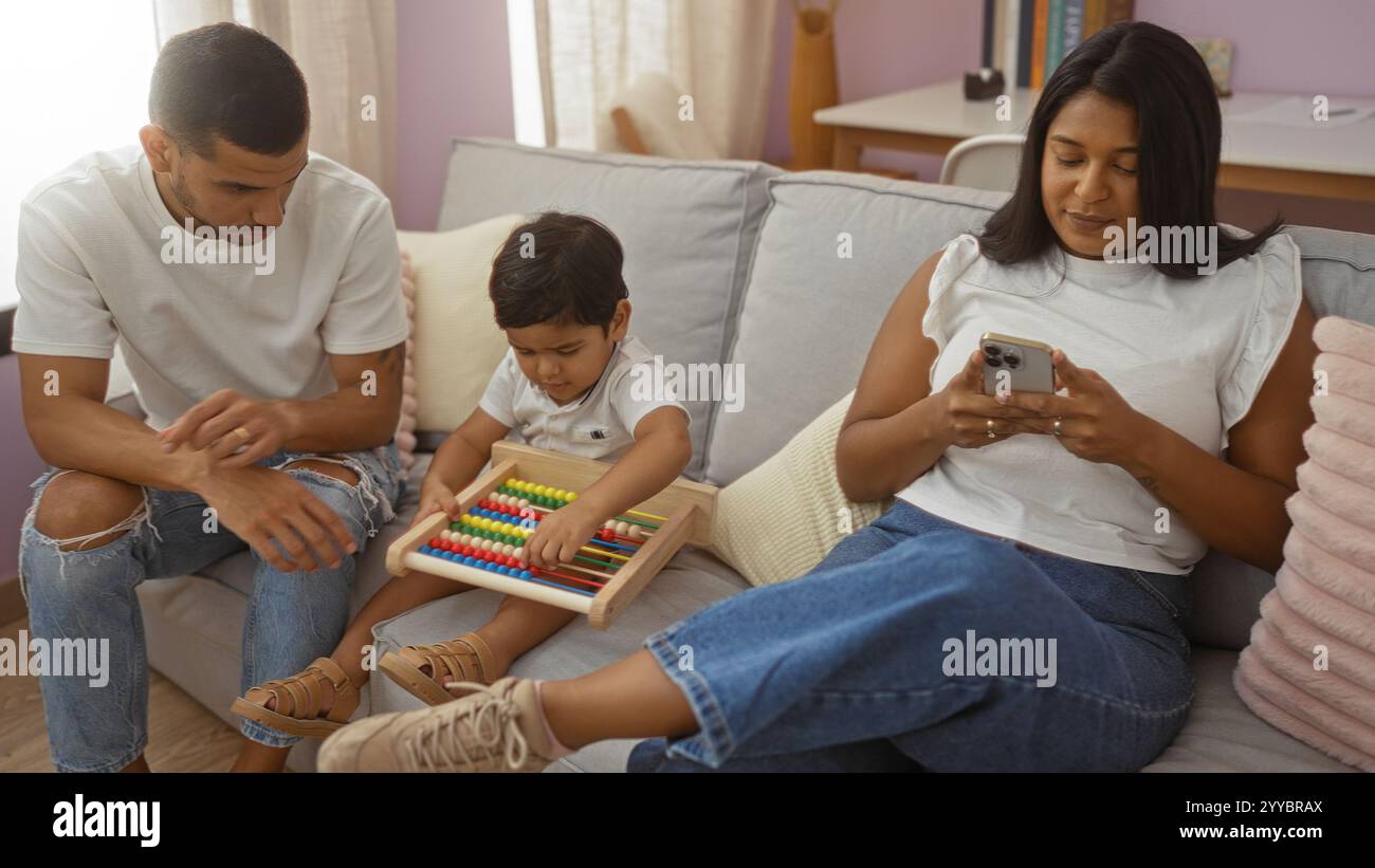 Woman using a mobile phone while a man and a child play with an abacus ...