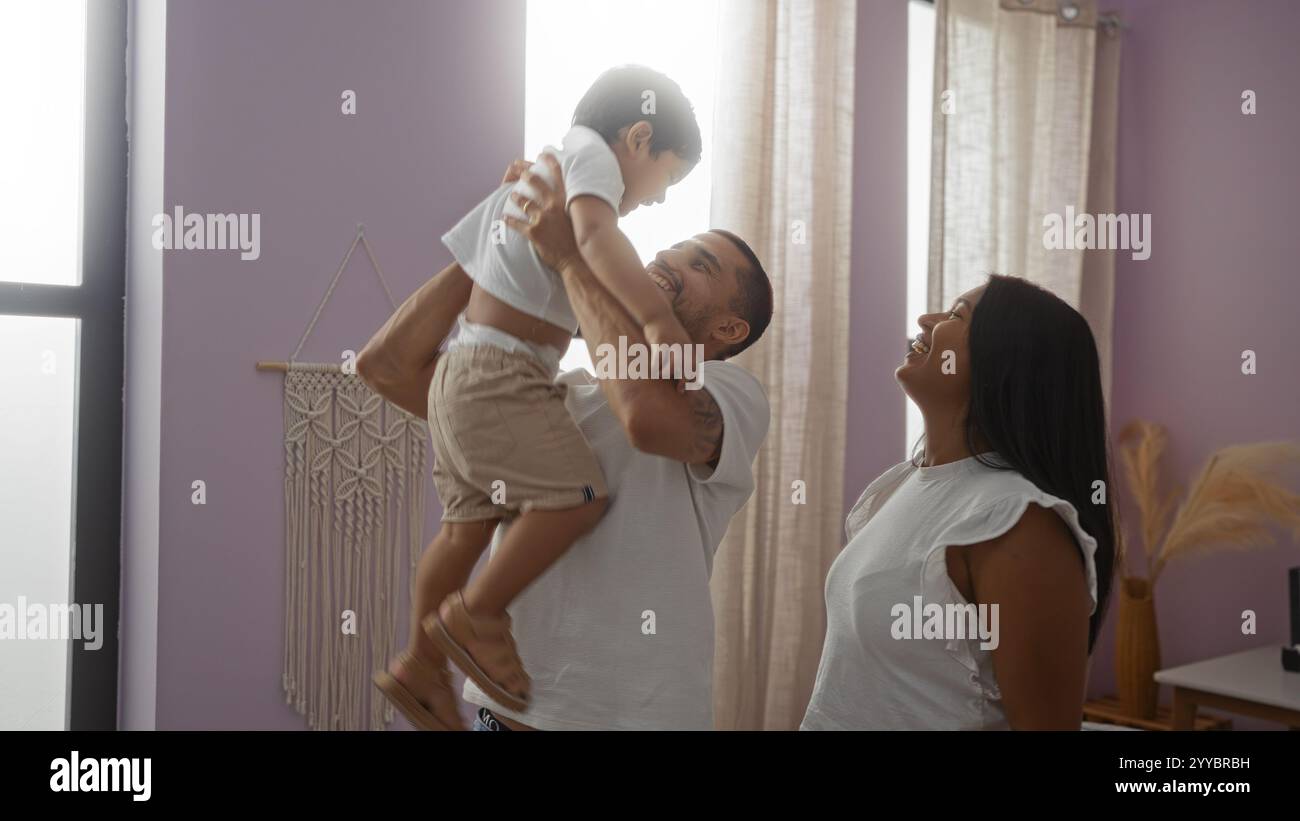 Happy family with woman and man lifting child in cozy living room with ...