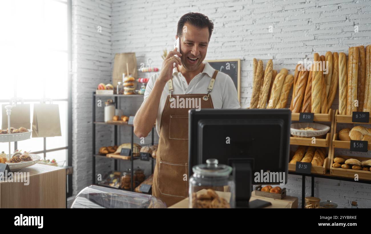 Hispanic man working in a bakery talking on the phone surrounded by ...