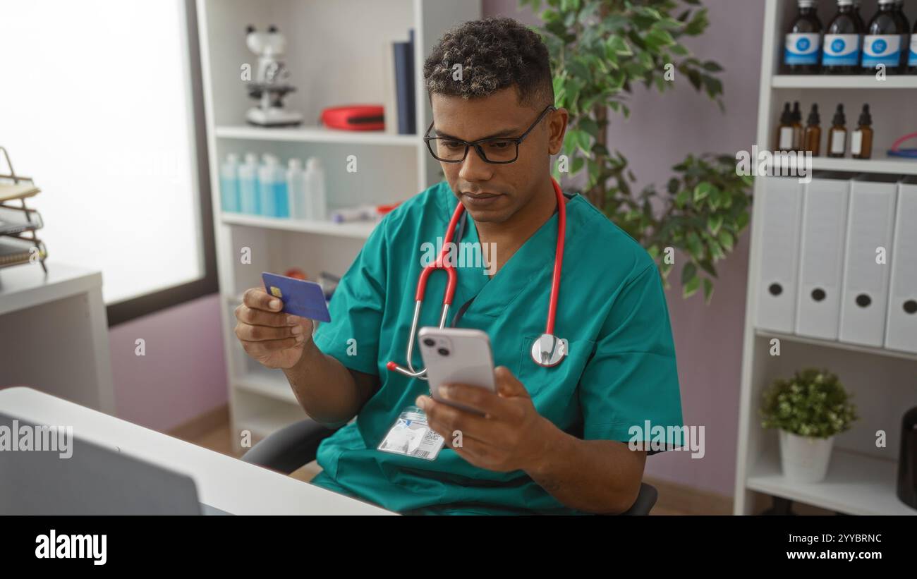 Hispanic male nurse in green scrubs uses smartphone and credit card in ...