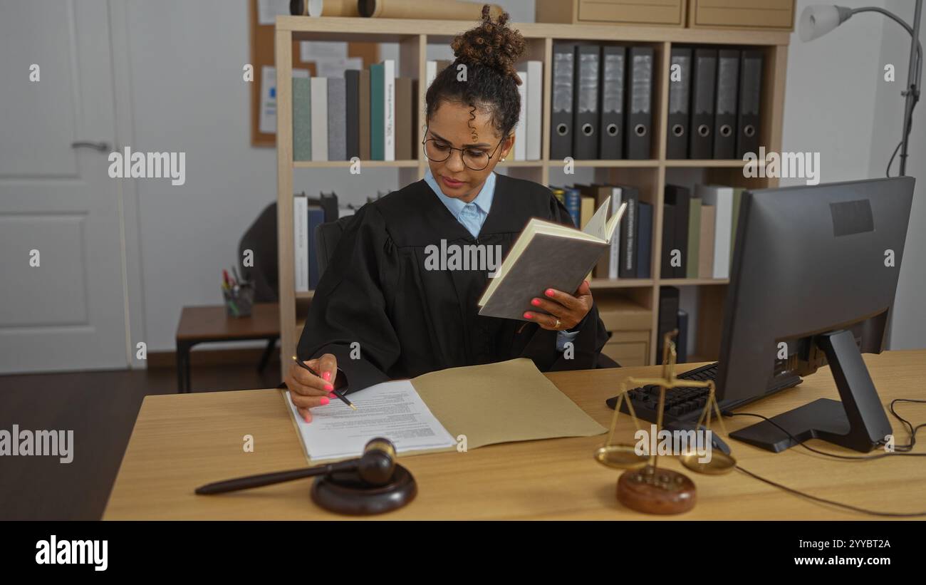 Woman judge taking notes and reading a book in an office with legal ...