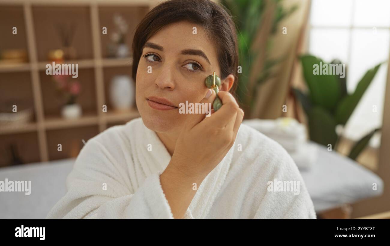 Hispanic woman in spa wellness room using jade roller on face, focusing on self-care and ...