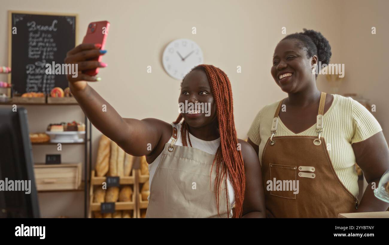 African american women bakers in an indoor bakery shop smiling and ...