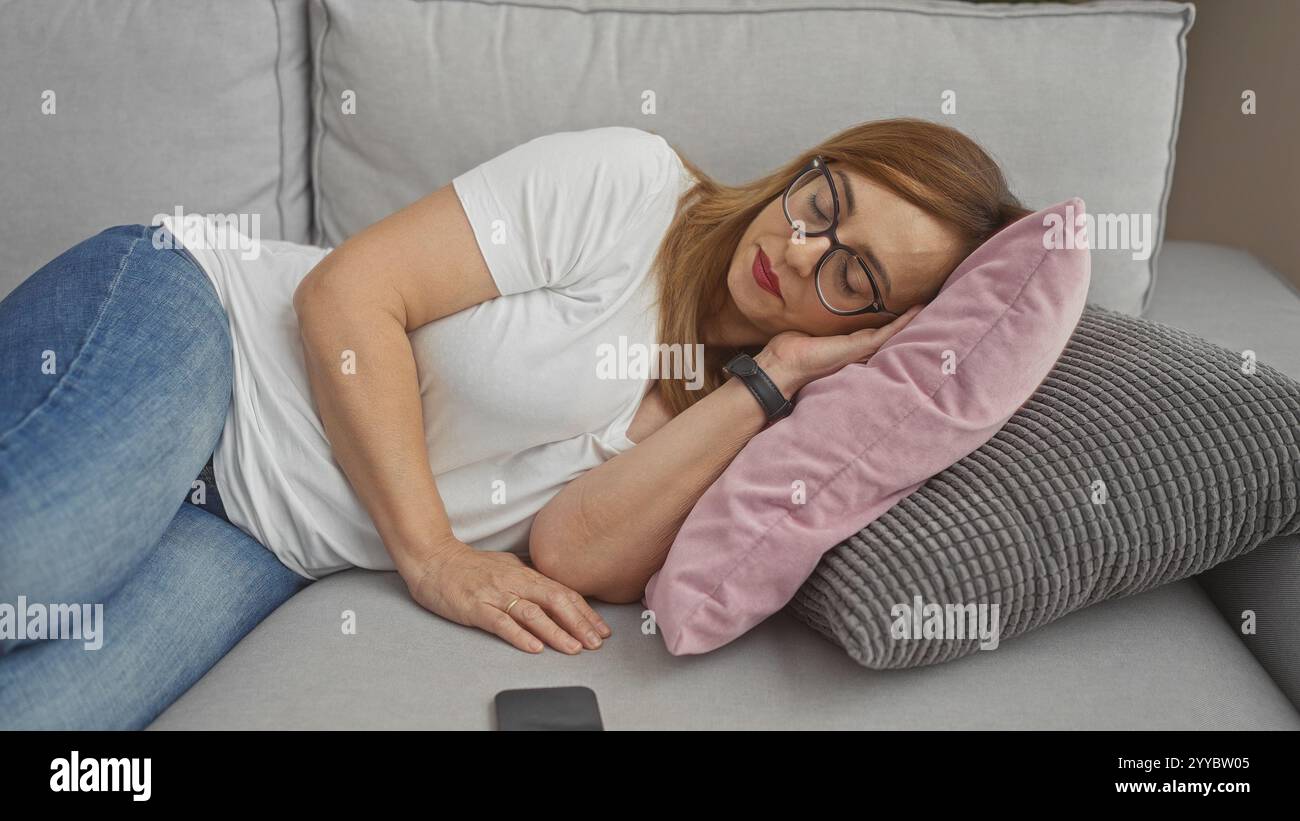 Woman sleeping on a couch with glasses in a living room, leaning on a ...