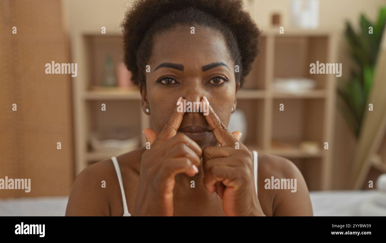 Woman with curly hair in a spa room tapping her nose, emphasizing self ...