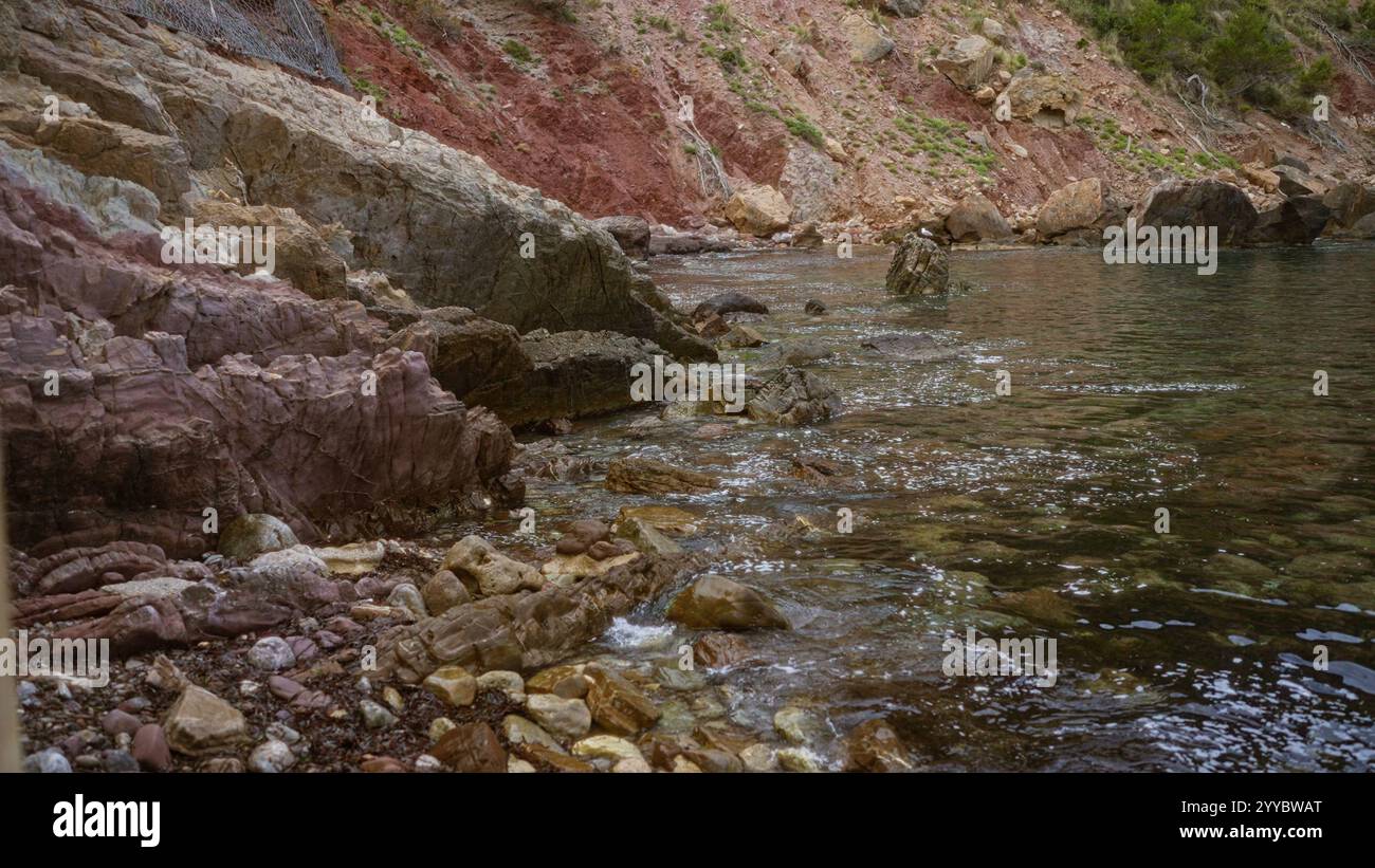 Coastal shoreline with rocky landscape and calm waters with distant ...