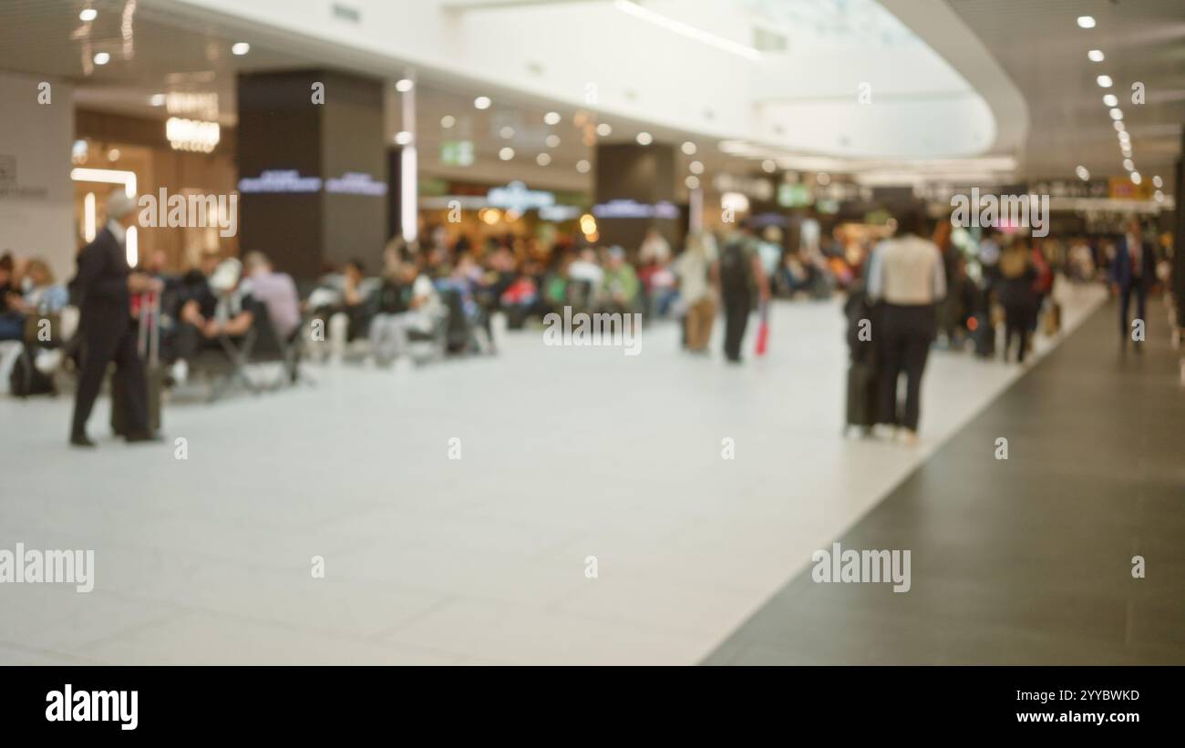 Blurred scene at an airport interior showing defocused travelers and ...