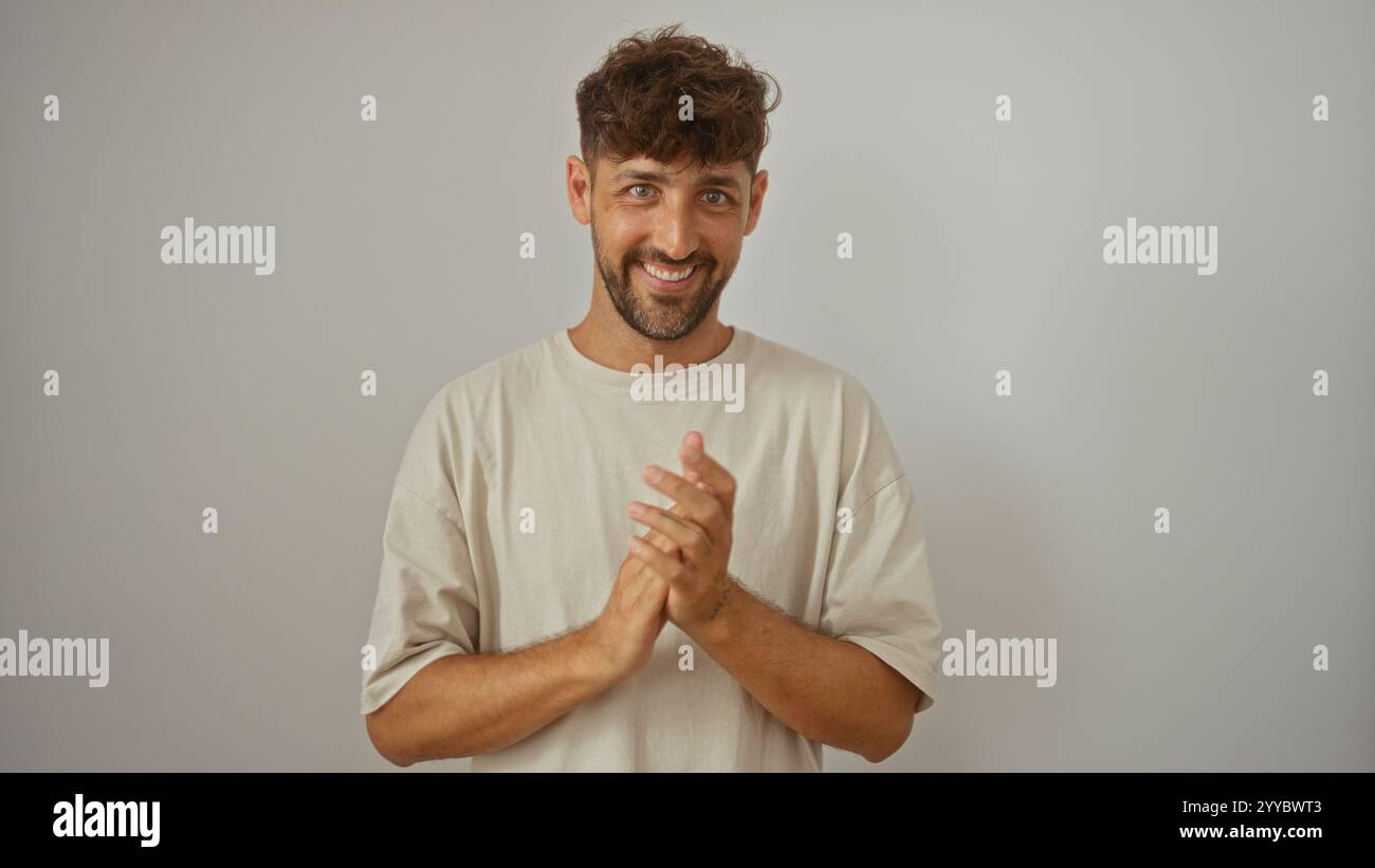 Attractive young man clapping in front of an isolated white background ...