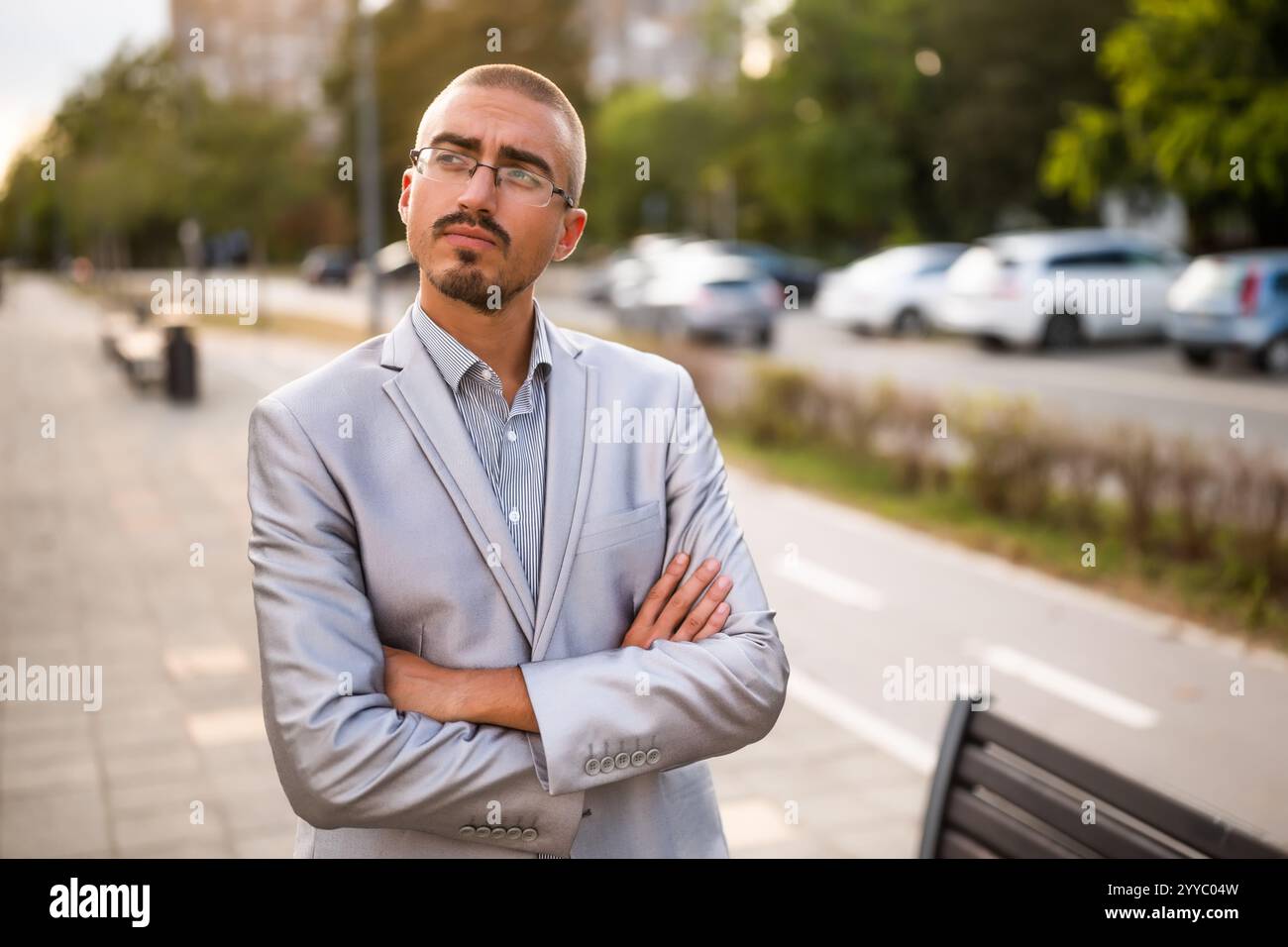 Portrait of thoughtful and distraught young businessman who is standing ...