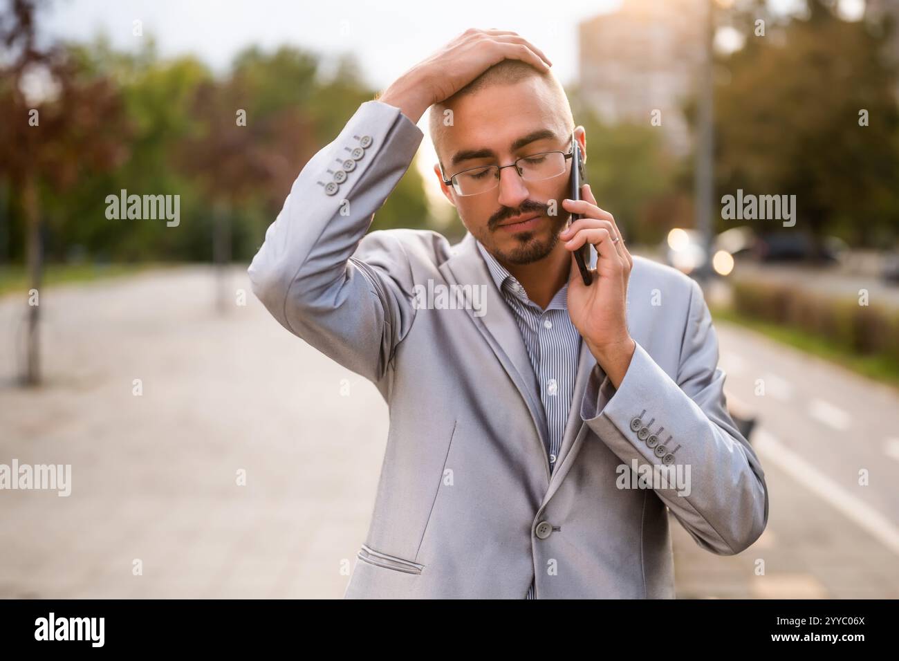 Portrait of distraught businessman who is talking on phone. Young ...