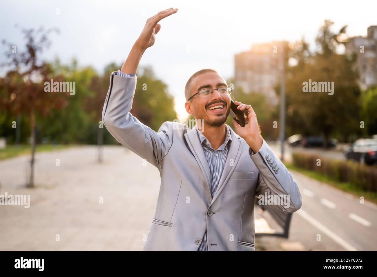 Portrait of cheerful businessman who is talking on phone. Young ...