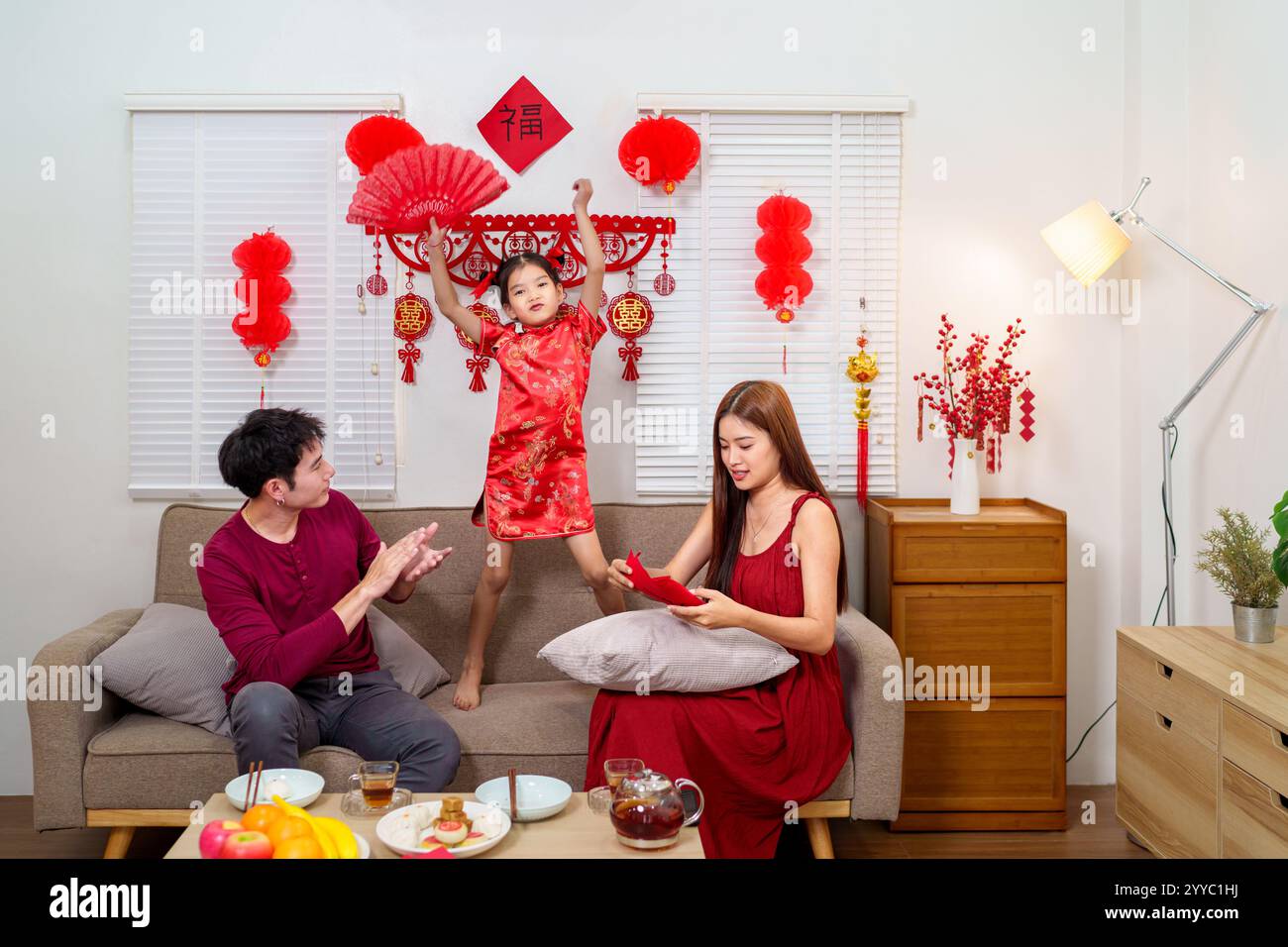 A cheerful Chinese family celebrates Chinese New Year as the parents ...