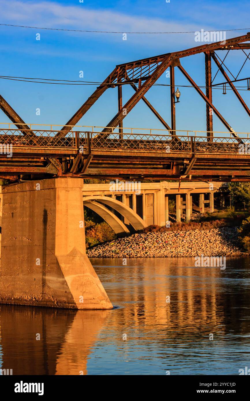 A bridge spans a river with a reflection of the bridge in the water ...