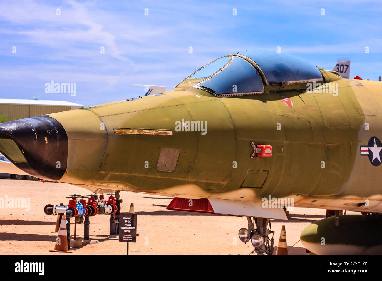 A green fighter jet is parked on the ground. The plane is on display ...