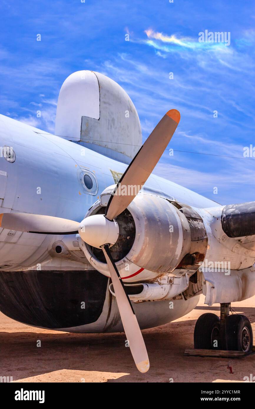 A propeller plane is parked on the ground with its propeller facing the ...