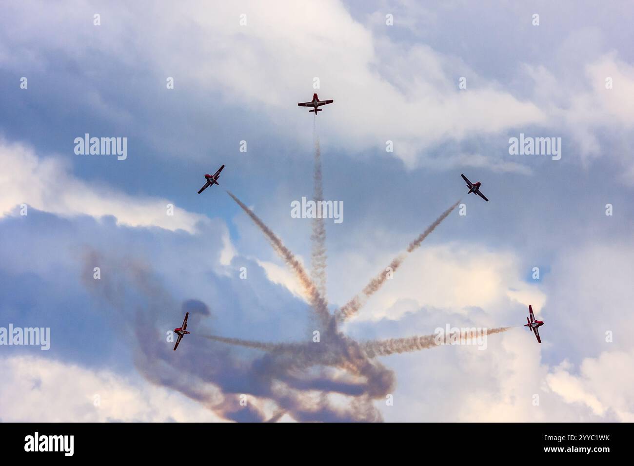 A group of five fighter jets are flying in formation, leaving a trail ...