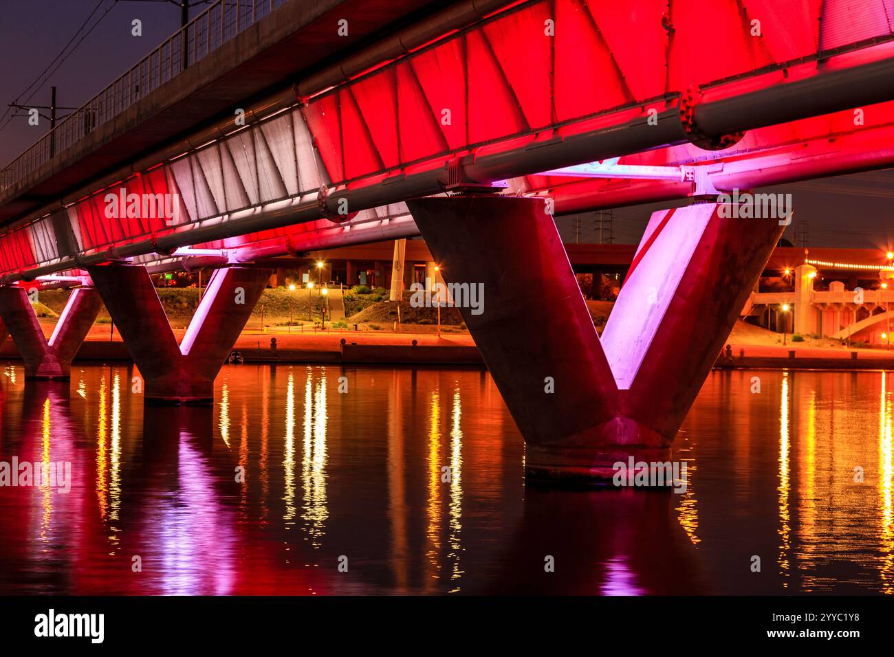 A bridge with red lights shining on it. The lights are on the bridge ...