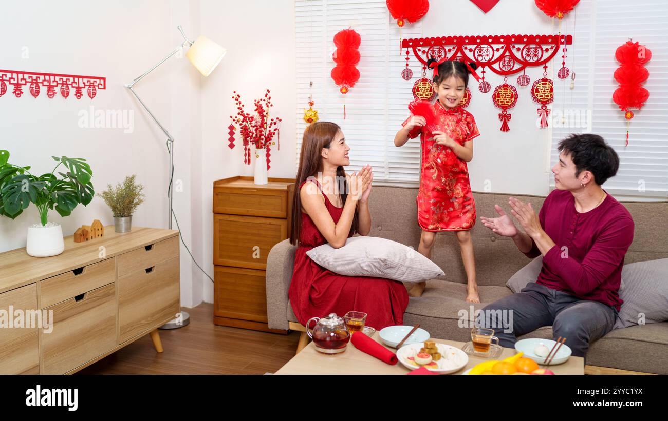 A cheerful Chinese family celebrates Chinese New Year as the parents ...