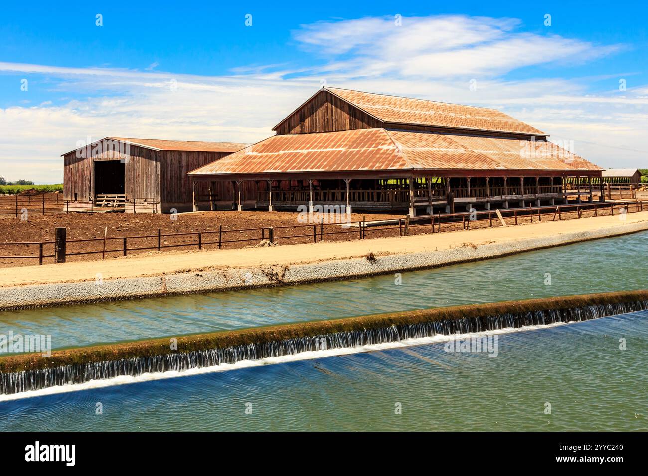 A farm with a barn and a waterway. The barn is old and the waterway is ...