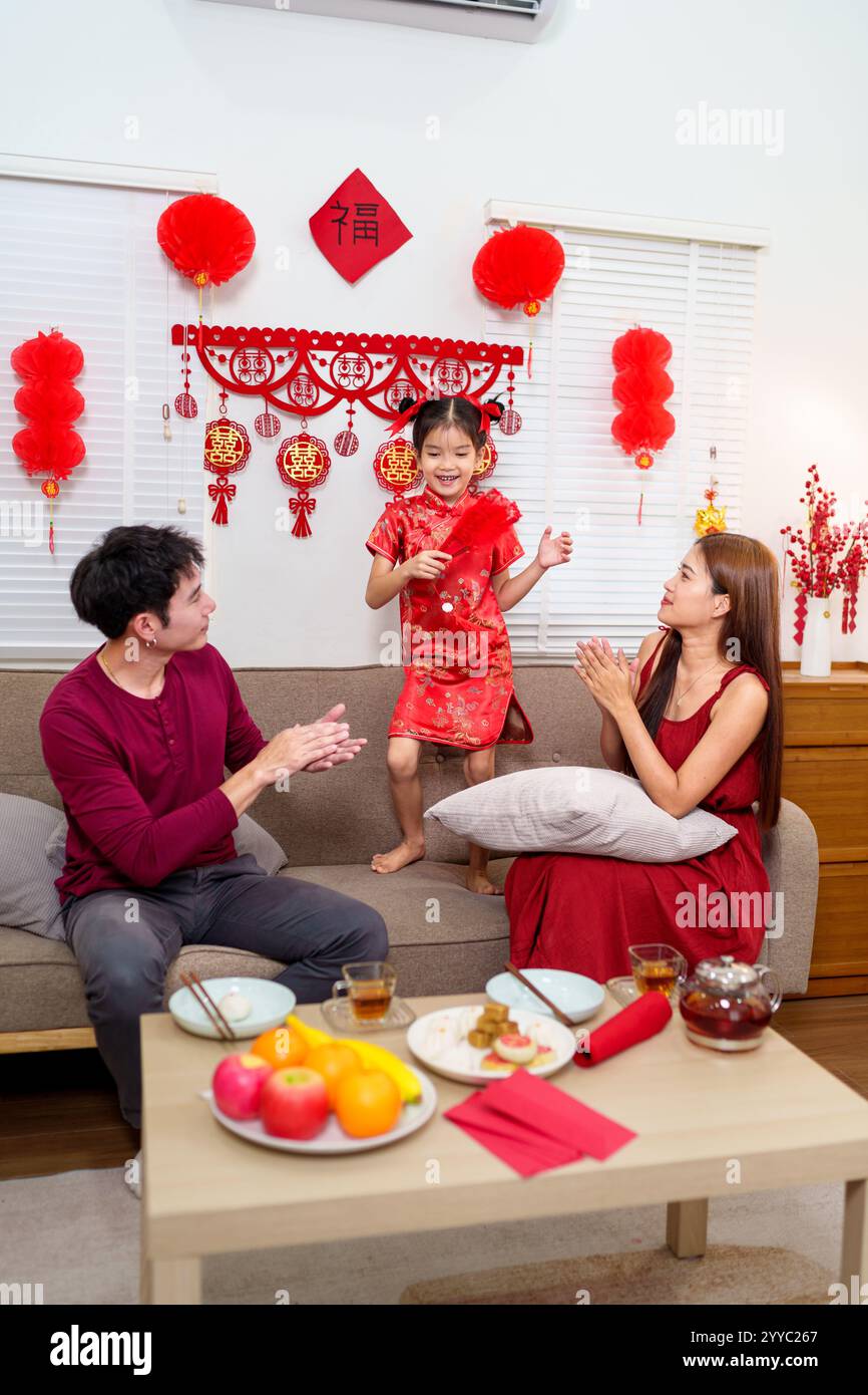 A cheerful Chinese family celebrates Chinese New Year as the parents ...