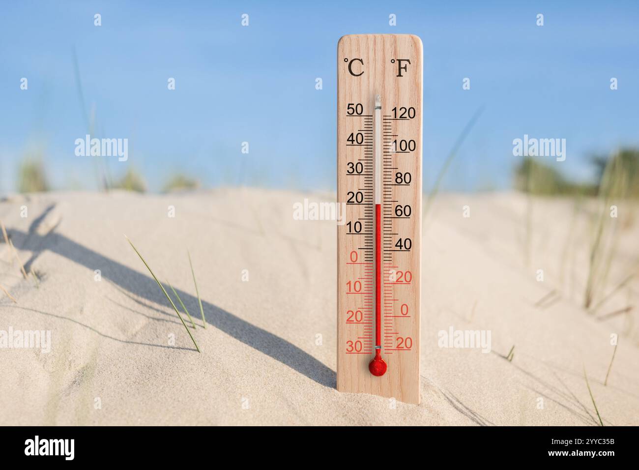Wooden celsius and fahrenheit scale thermometer in the sand. Ambient ...