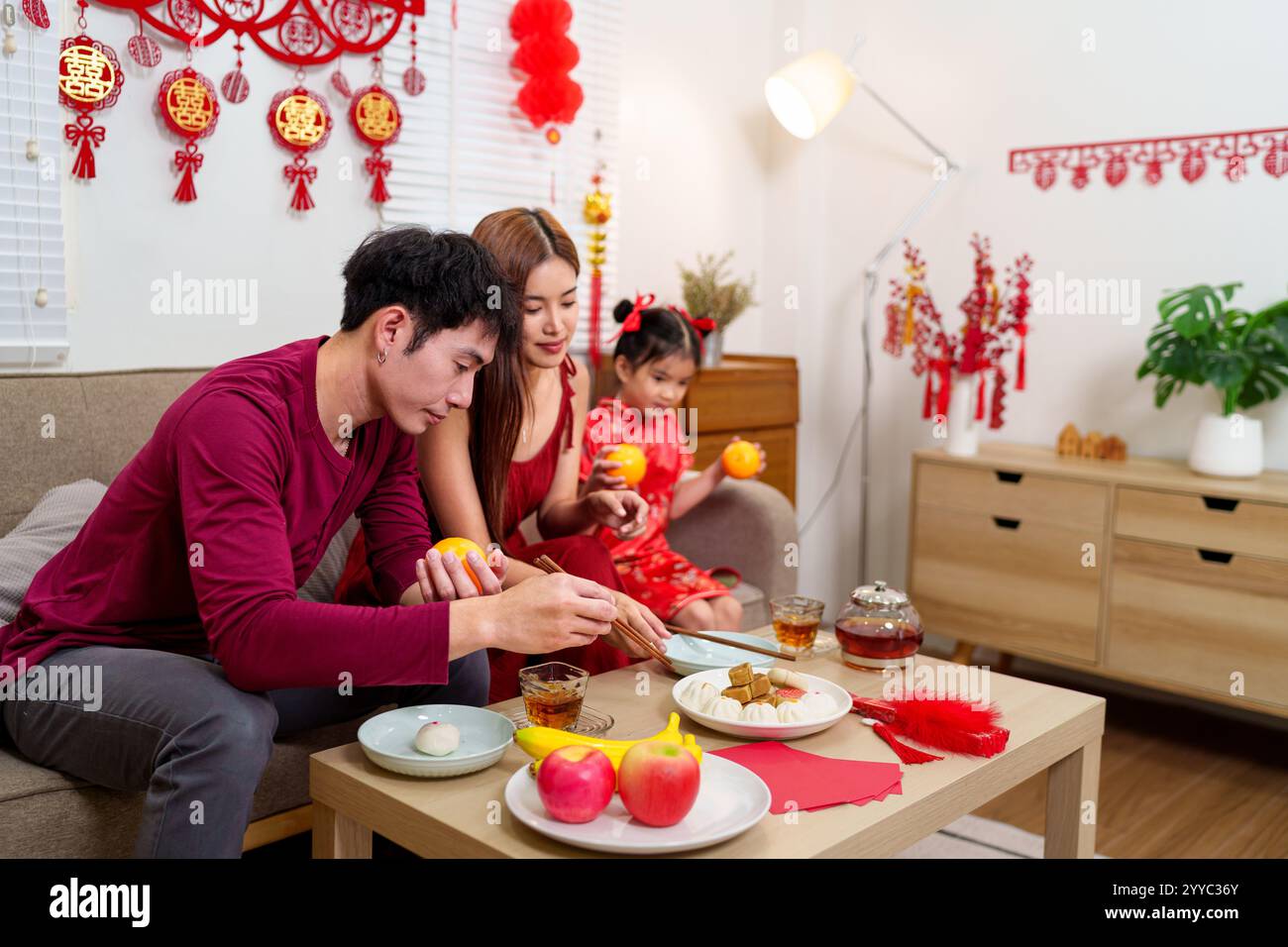 A Chinese family of three arranges a festive dining table to celebrate ...