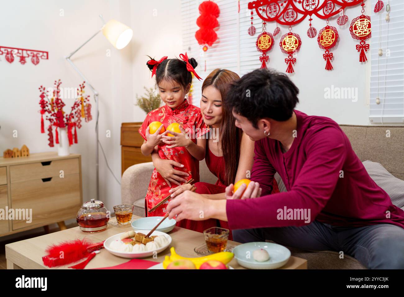 A Chinese family of three arranges a festive dining table to celebrate ...