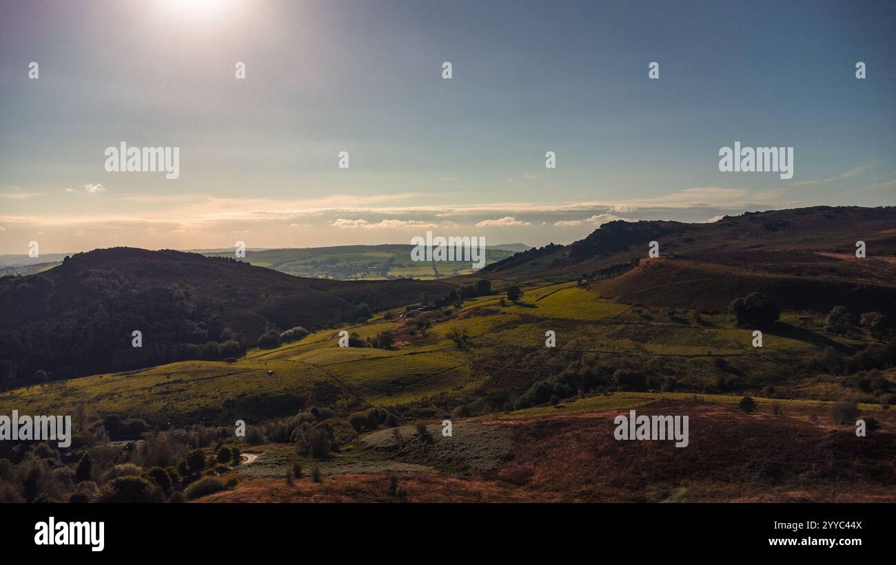 Rolling hills bathed in warm sunlight, rural countryside view with open ...