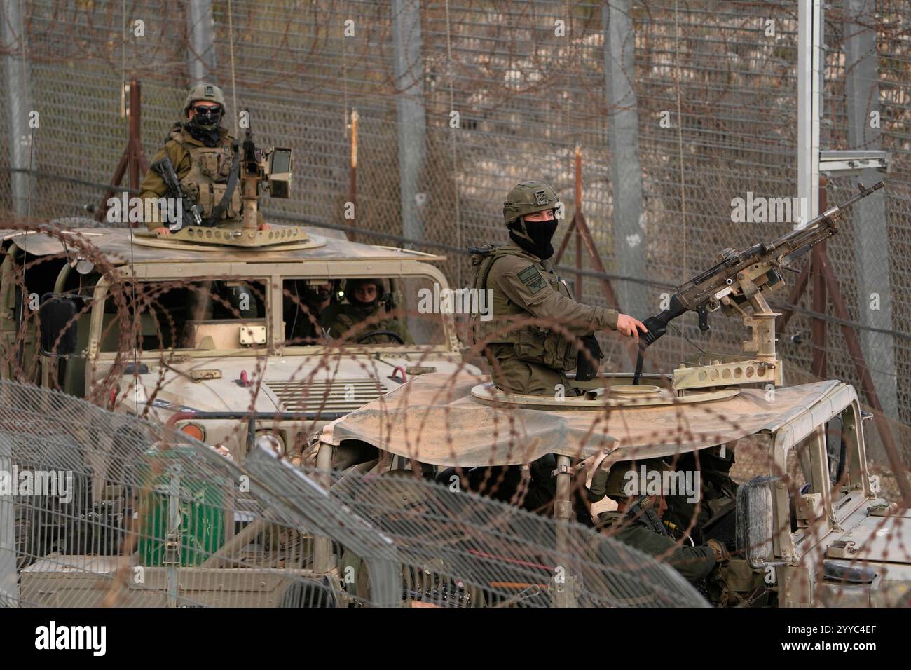 Israeli soldiers stand on armoured vehicles after crossing the security ...