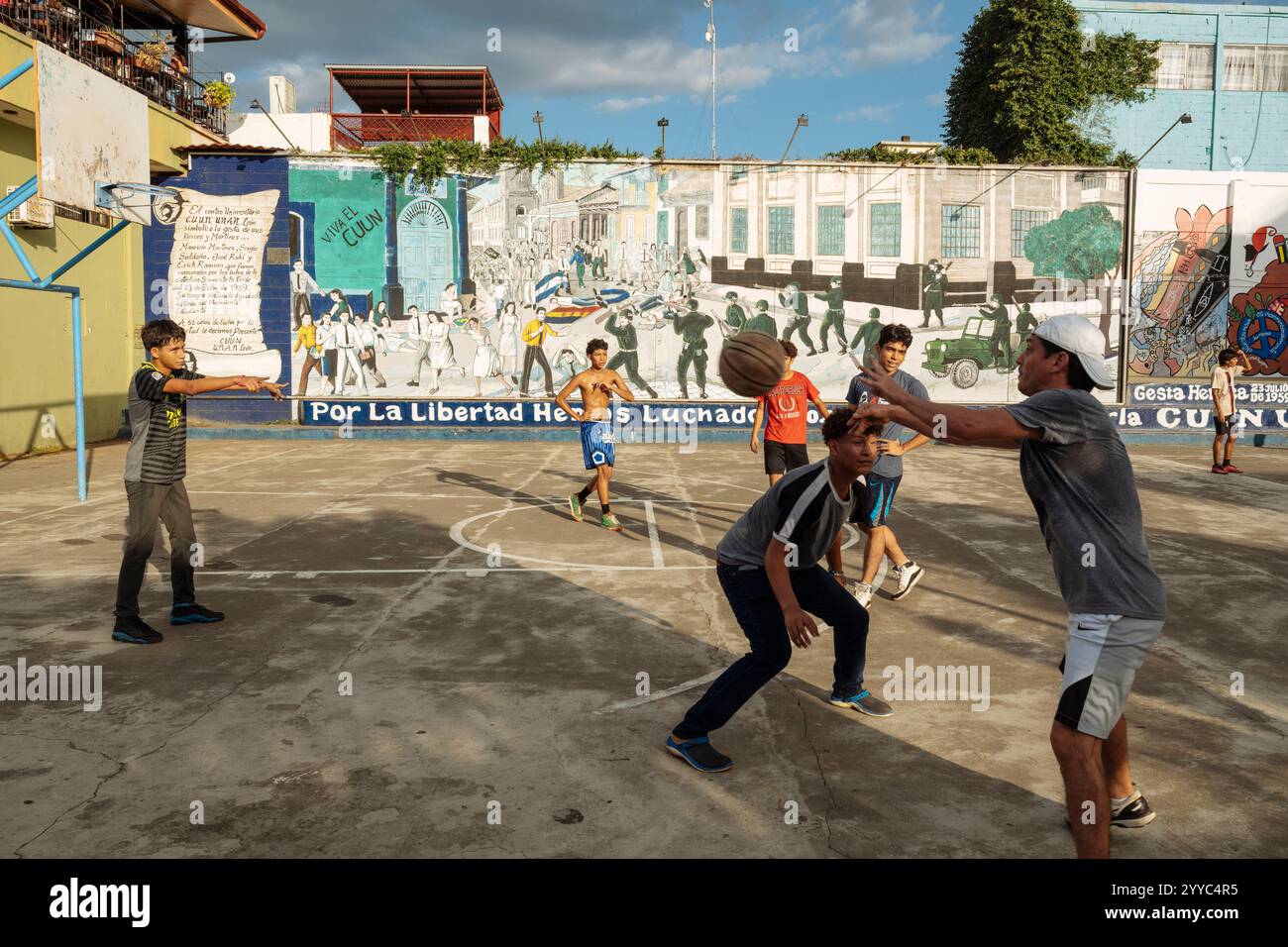 Basketball game in front of wall murals depicting the history of León ...