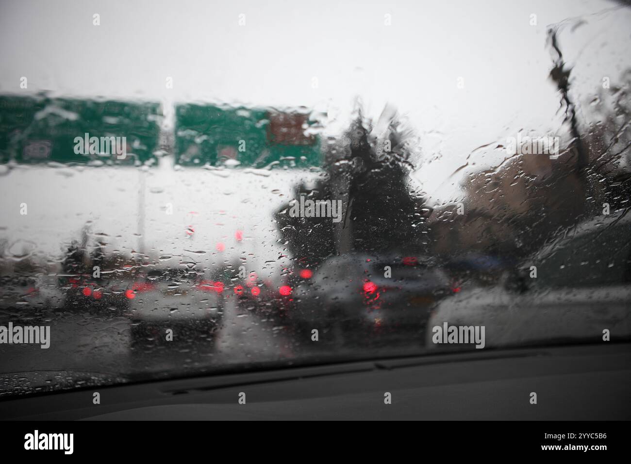 Out of focus cars, their back lights on, traffic lights, street signs ...