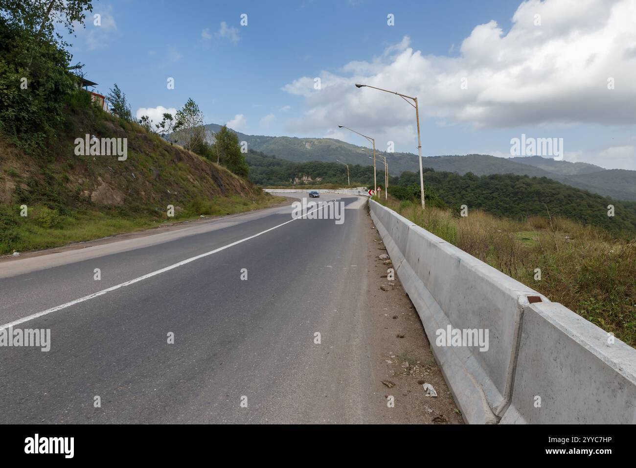 A winding road in Gilan Province showcases the lush green hills, with a ...