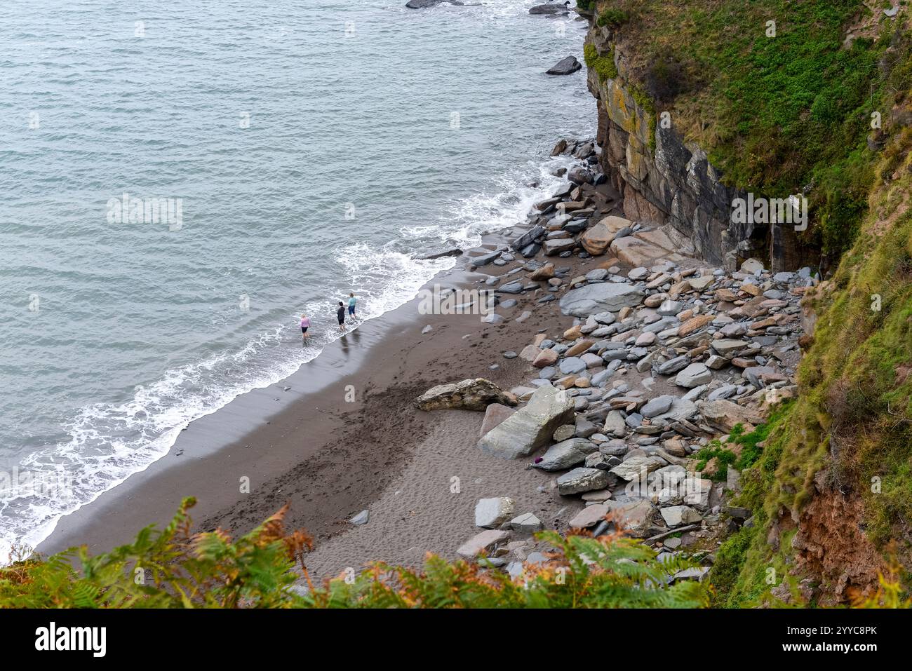 People on secluded beach below cliffs, North Devon coast, UK Stock ...