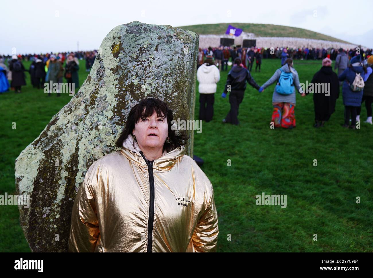 Edel Maria, from Offaly, leans against a stone as people gather for ...