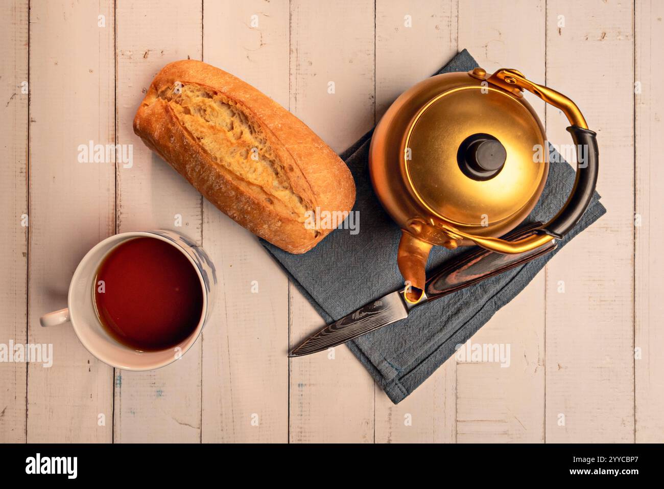 A gold-colored aluminum teapot along with a porcelain frying pan and ...