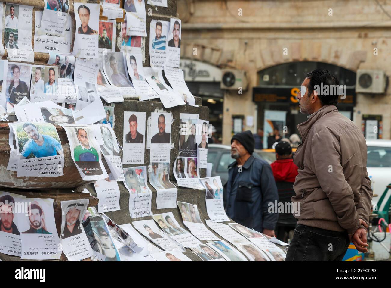 Syrian people look at photos of people reported to be missing by ...