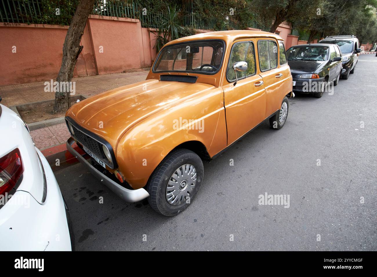 old vintage gold coloured renault 4 car parked on the street in ...
