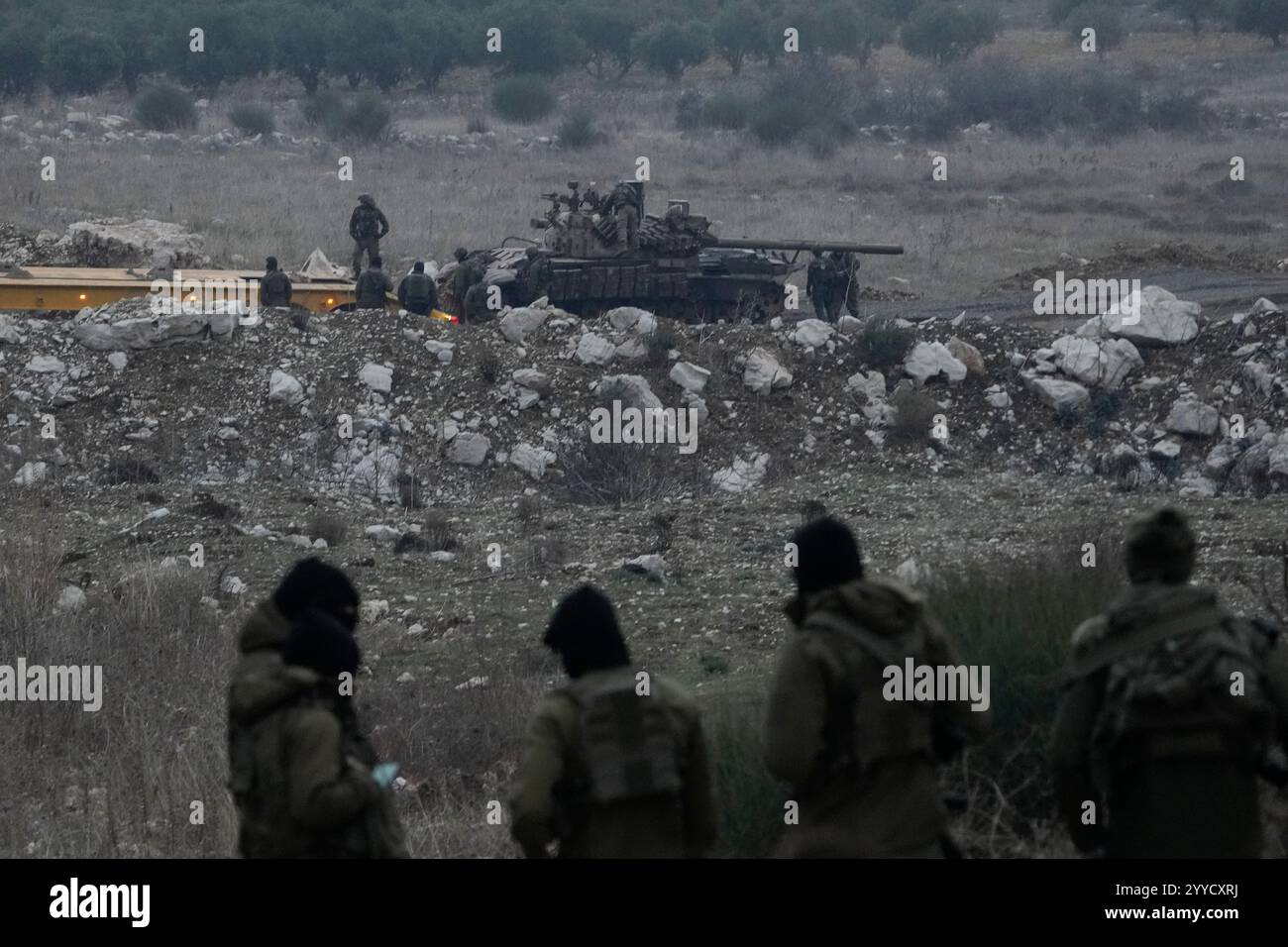 Israeli soldiers loads on a truck a Syrian tank inside the buffer zone ...