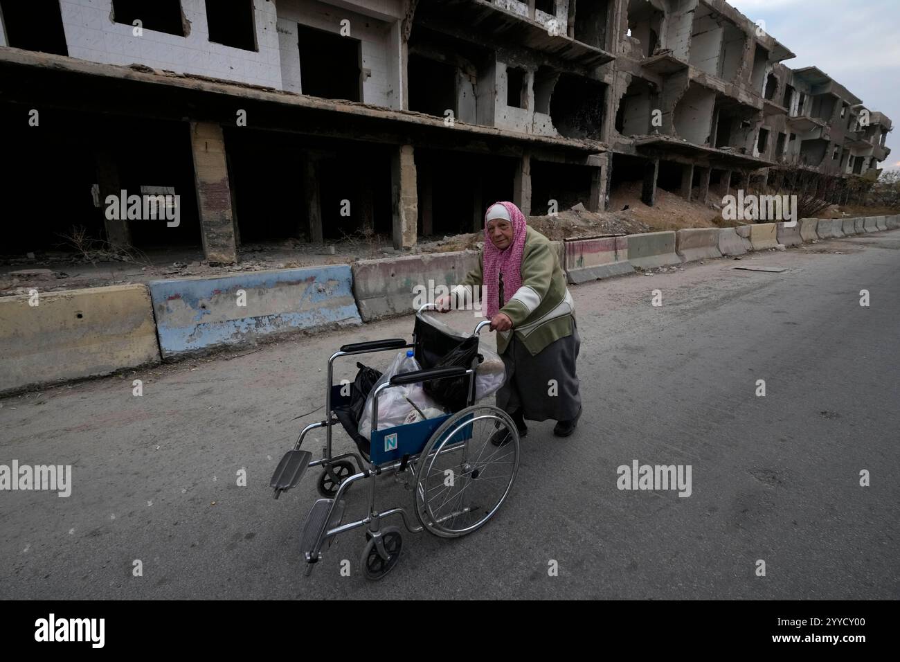 A Syrian woman pushes her wheelchair in the neighbourhood of Jobar, in ...