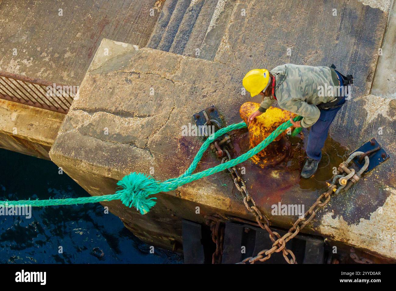 Worker Securing Rope on a Dockside Bollard for Maritime Safety Stock ...